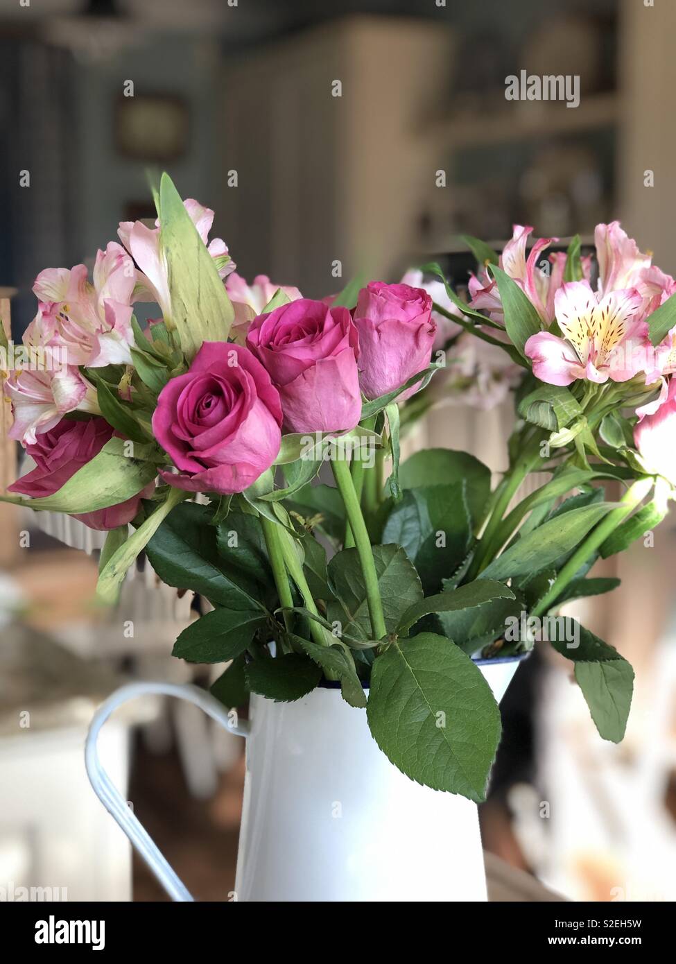 Fresh pink roses in vintage email jug in country kitchen Stock Photo ...