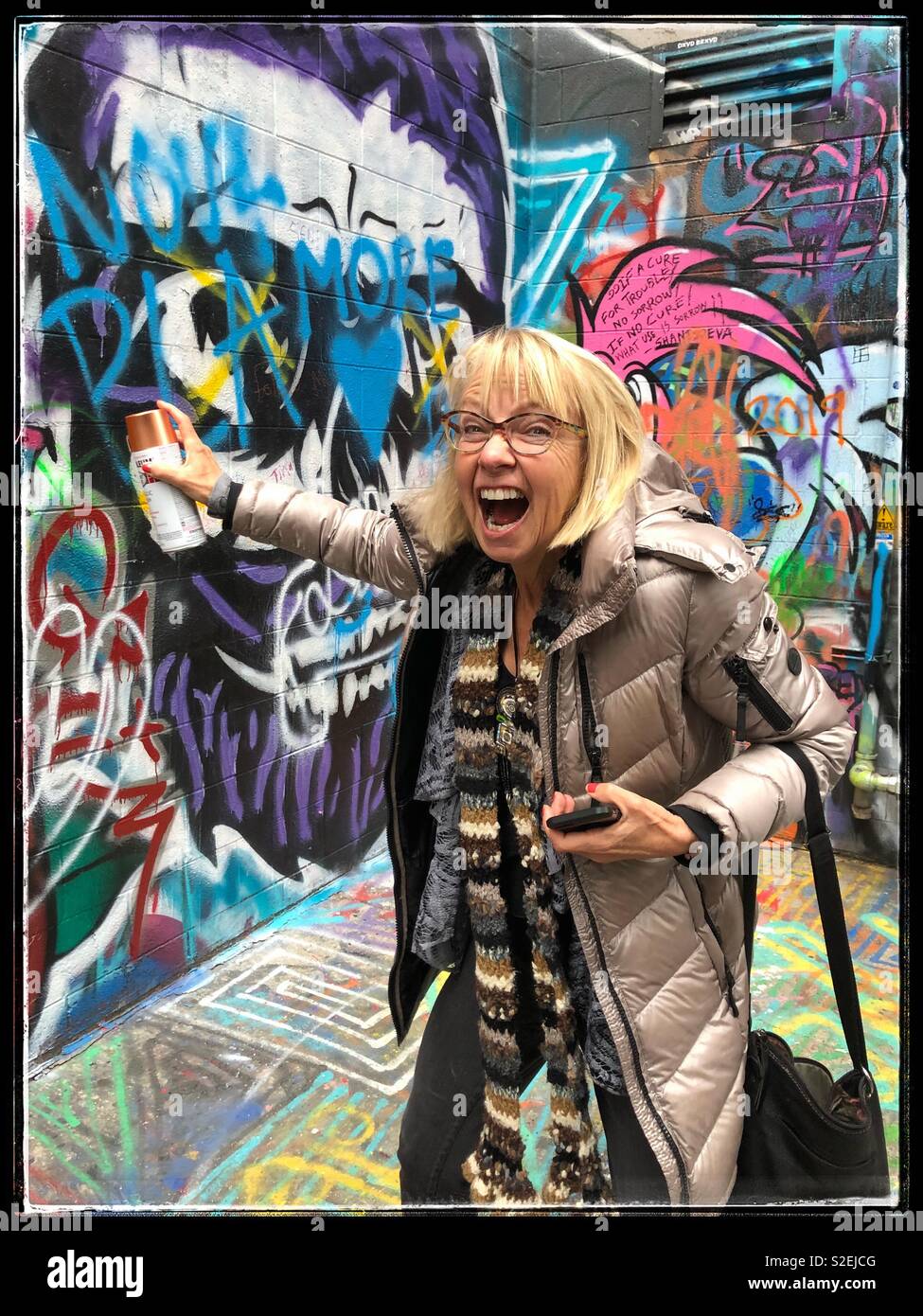 Woman spray painting colorful wall Stock Photo - Alamy
