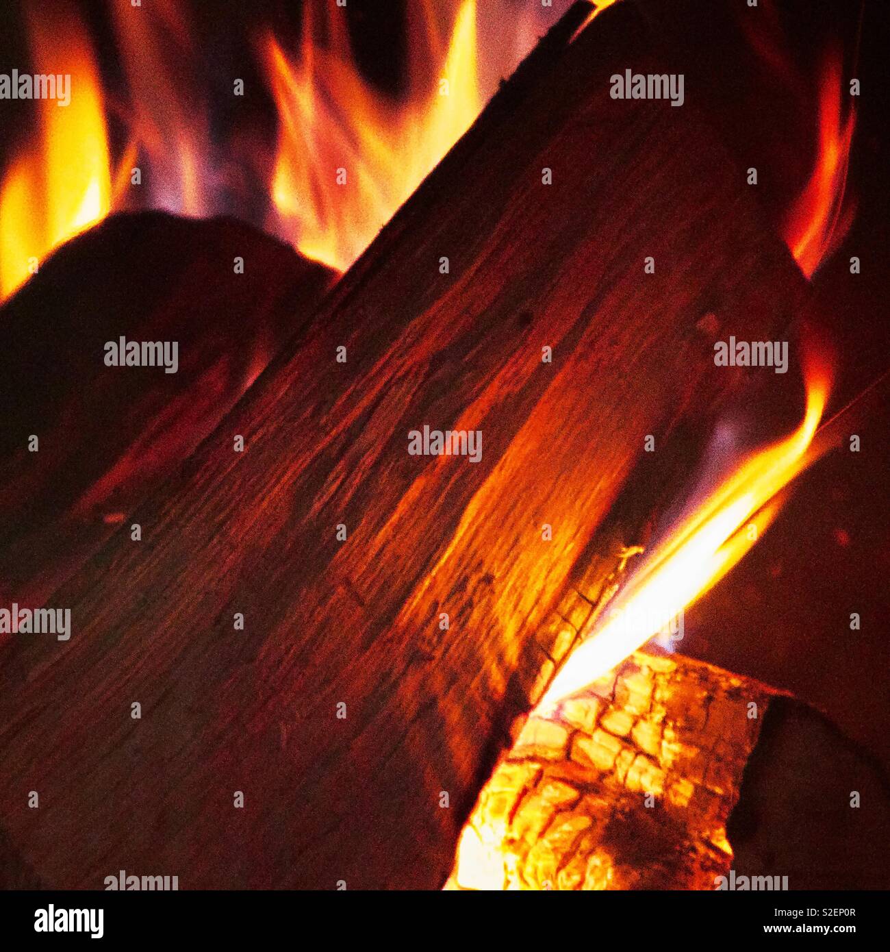 bright yellow red flames from burning logs in the fireplace create a ...