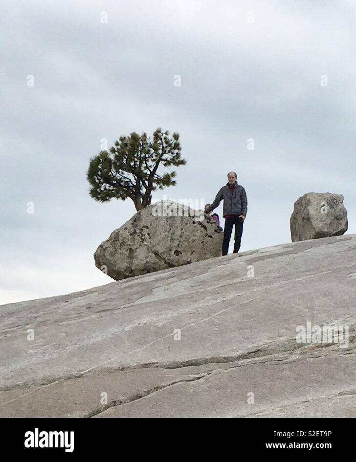 Man standing on rock with two rocks Stock Photo - Alamy