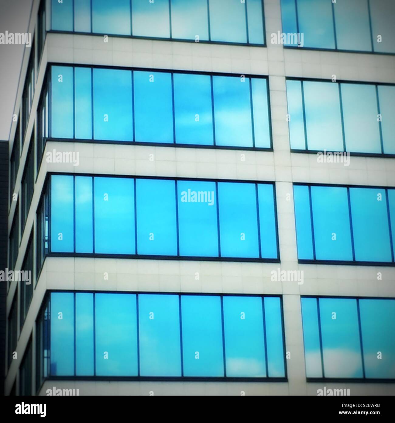 Office windows reflecting the blue sky Stock Photo - Alamy