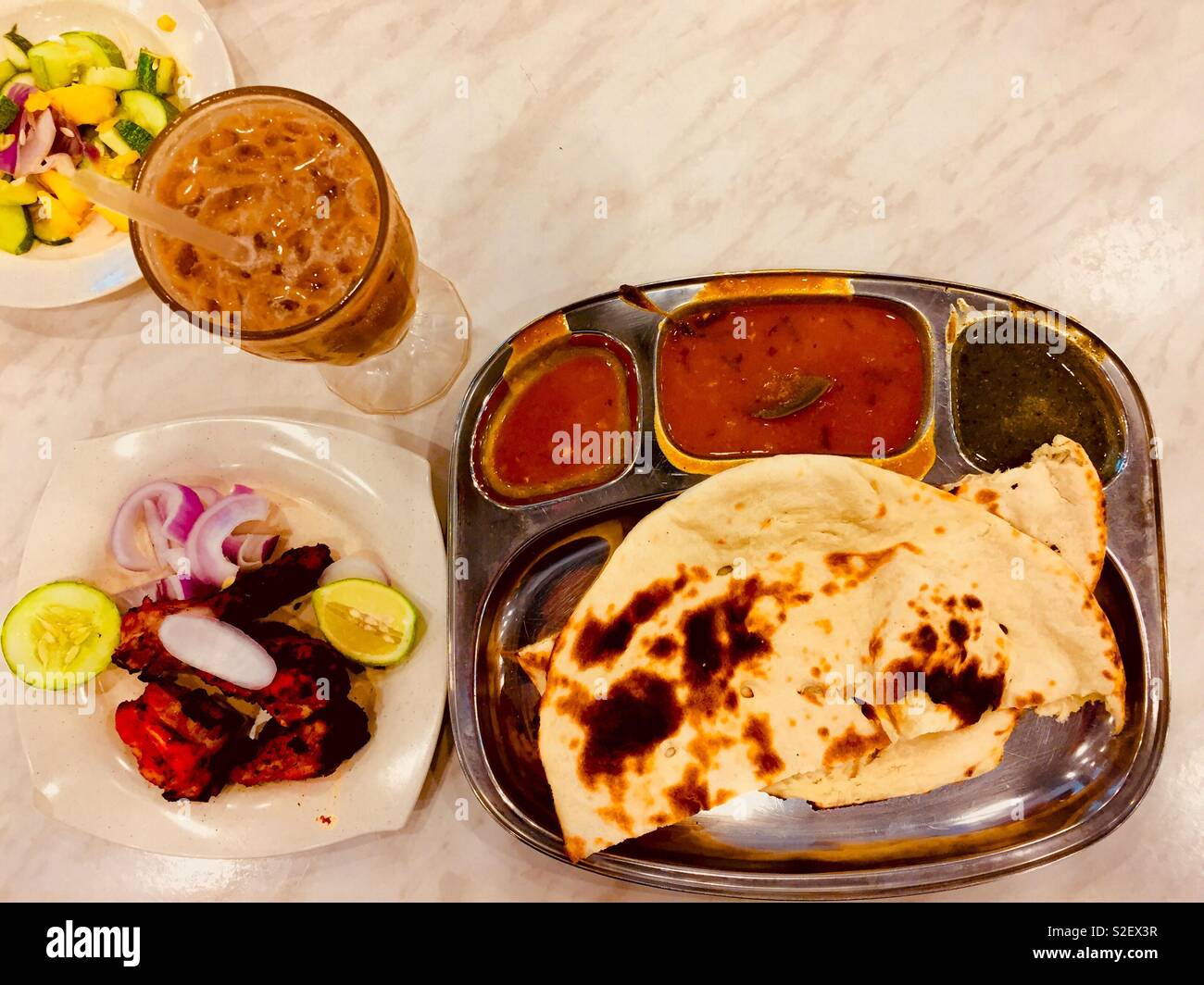 Chicken tikka with traditional naan bread and sauces, with iced coffee ...