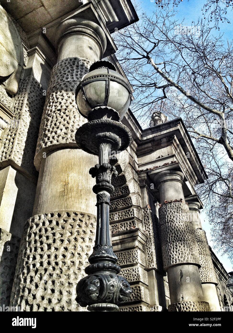 Cool ornate lamp standard and dimpled stonework on the facade of ...