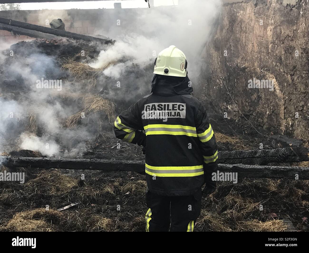 Firefighters at fire place Stock Photo - Alamy