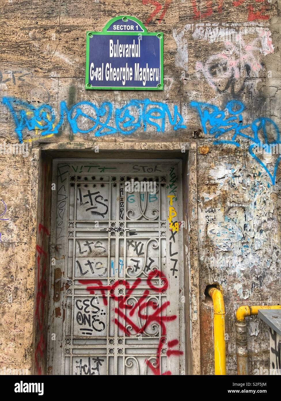 Graffiti on the exterior wall and door of a building in Bucharest ...