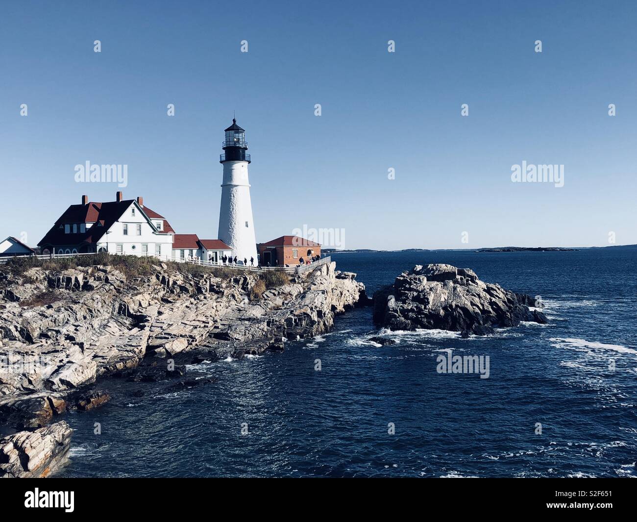 Lighthouse on rocky shoreline in Maine Stock Photo - Alamy