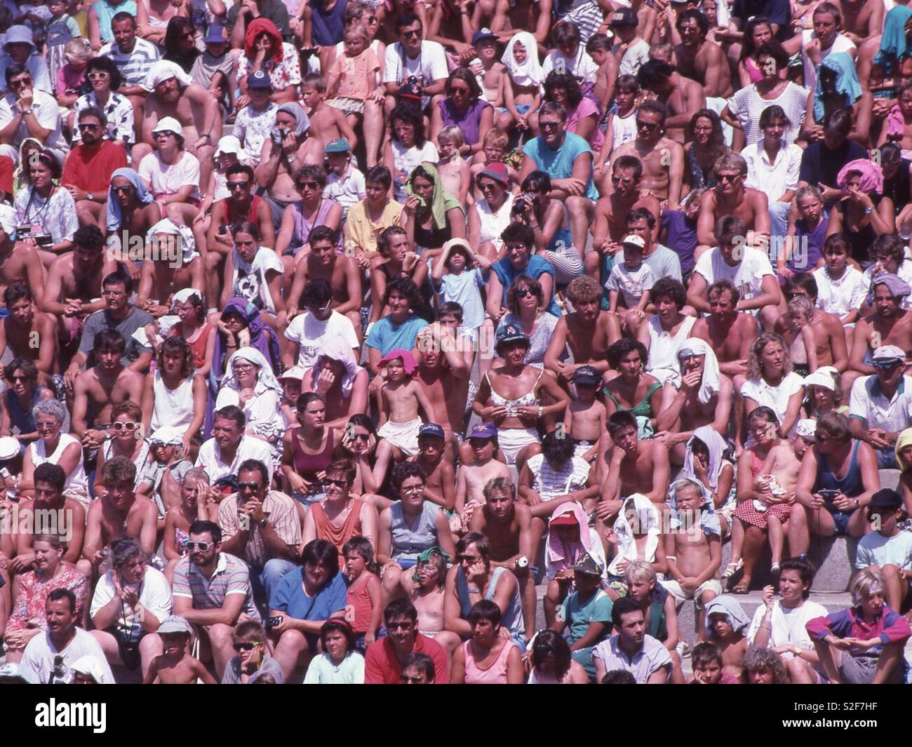 In The Sun - A Seated Crowd Stock Photo - Alamy