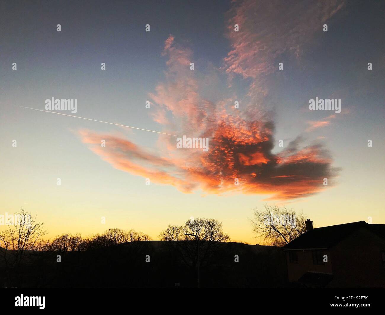 Colourful sunrise sky over houses and trees Stock Photo - Alamy