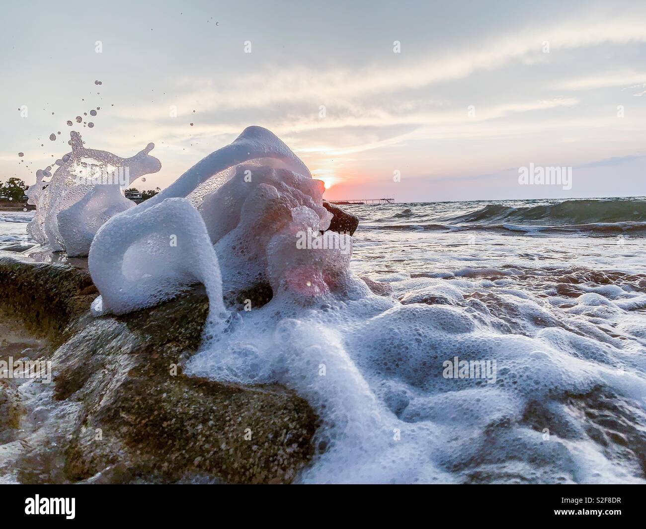 Nightcliff foreshore. Waves on rock at sunset Stock Photo - Alamy