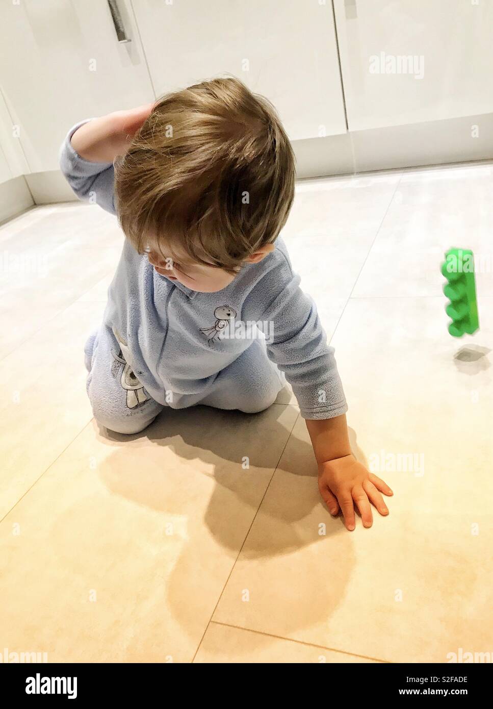 Toddler throwing mega block behind him Stock Photo - Alamy