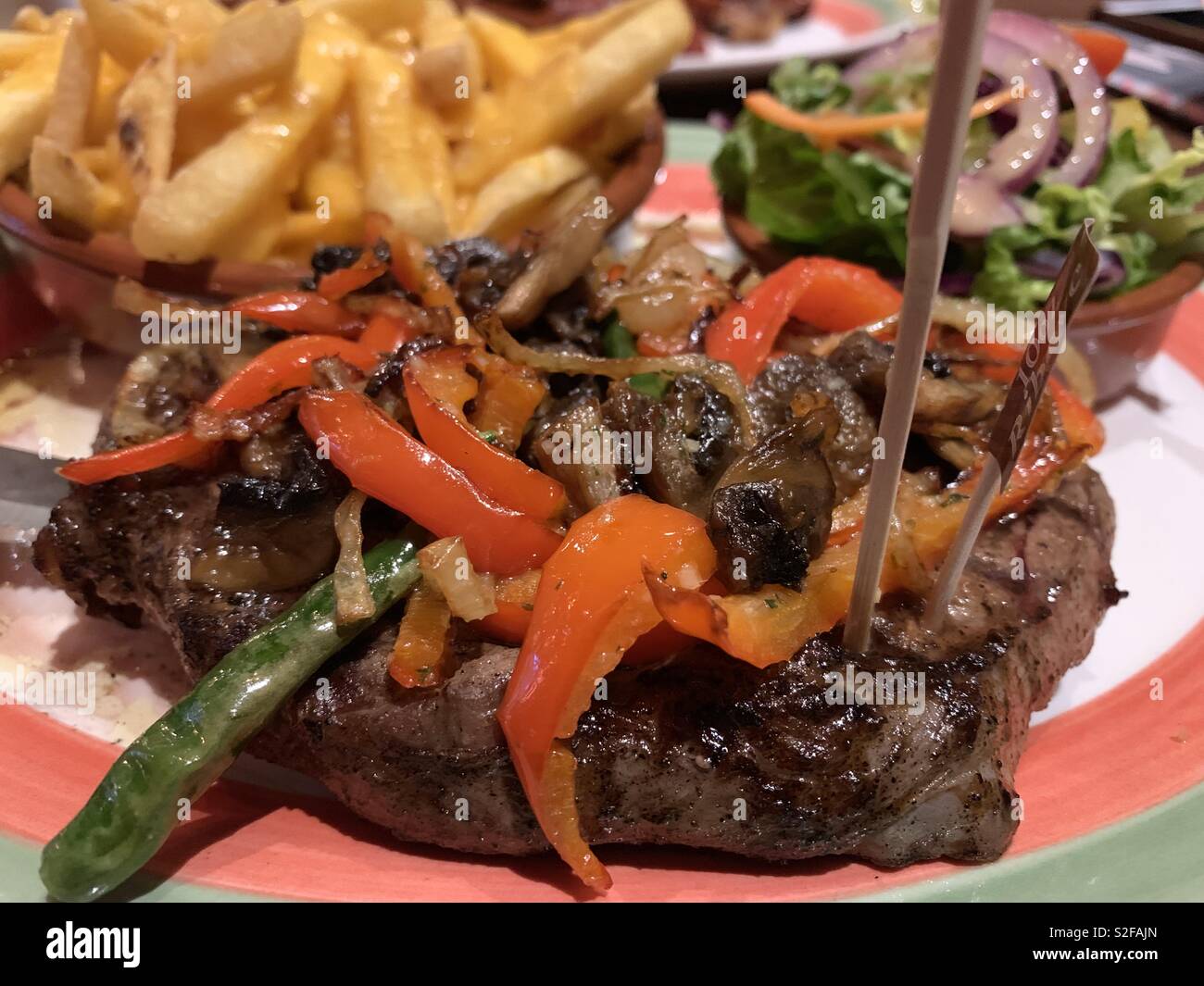 Medium rare steak & cheesy chips Stock Photo - Alamy