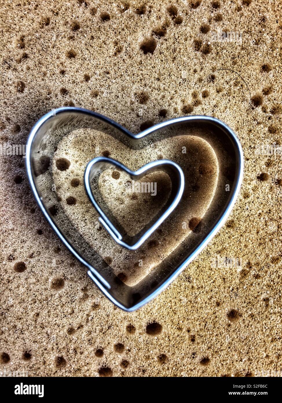 Little metallic hearts baking shapes on sponge background Stock Photo ...