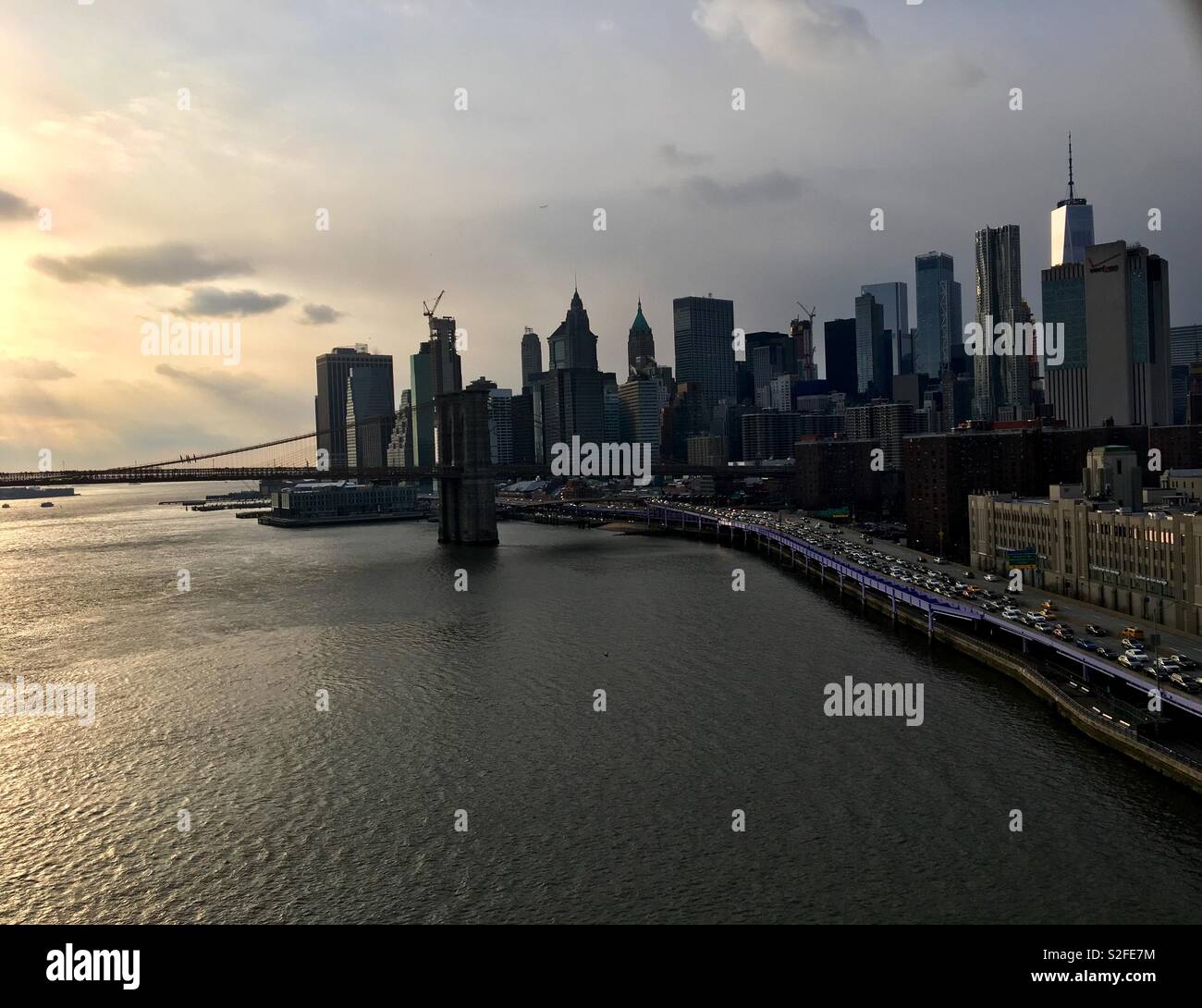 Manhattan skyline at dusk, with east river and a busy highway and the ...