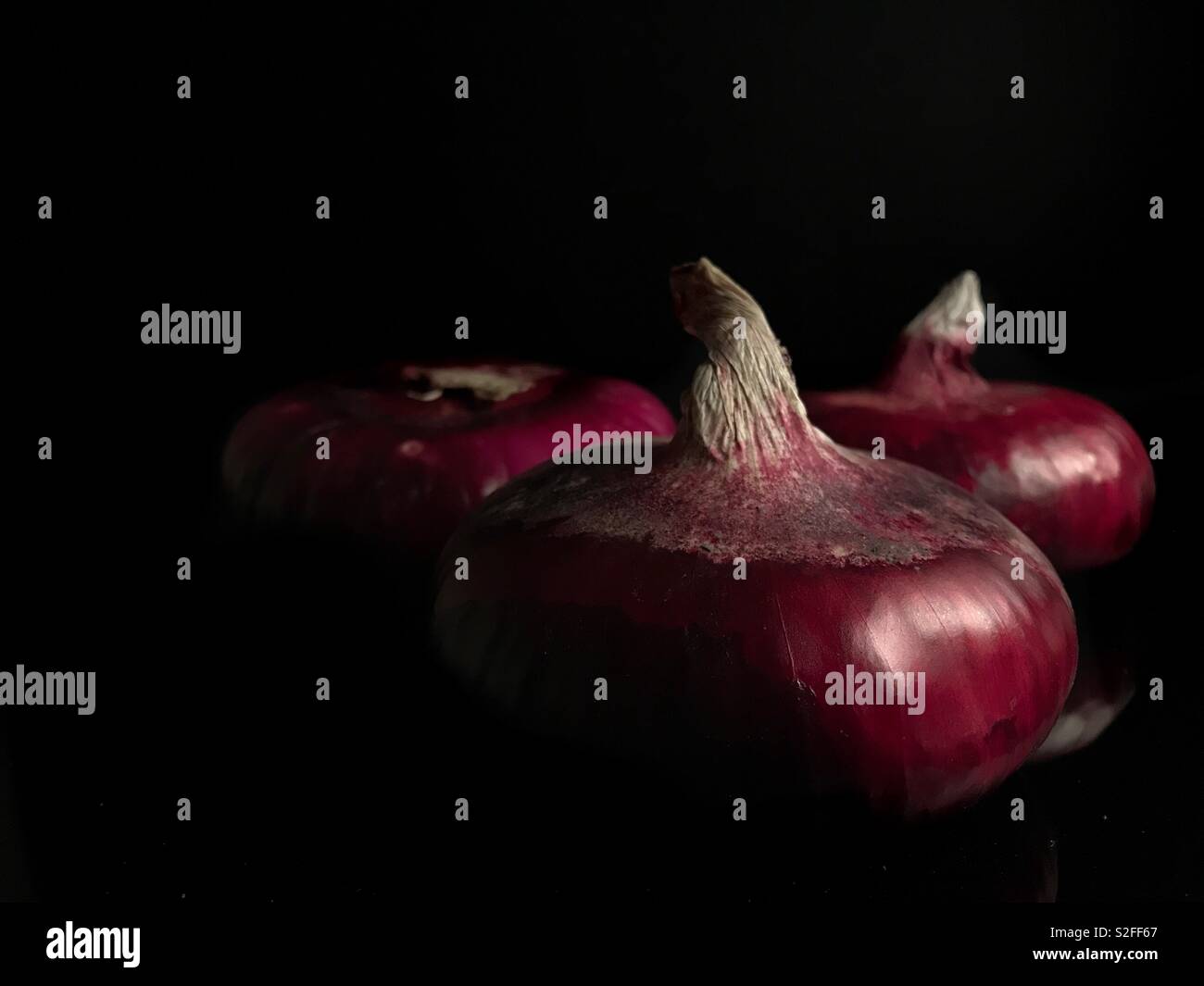 Three red onions Stock Photo - Alamy