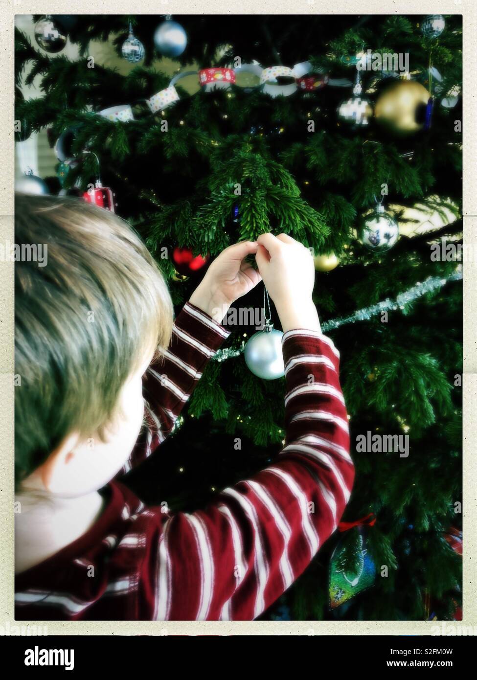 Small child decorating a christmas tree hi-res stock photography and ...