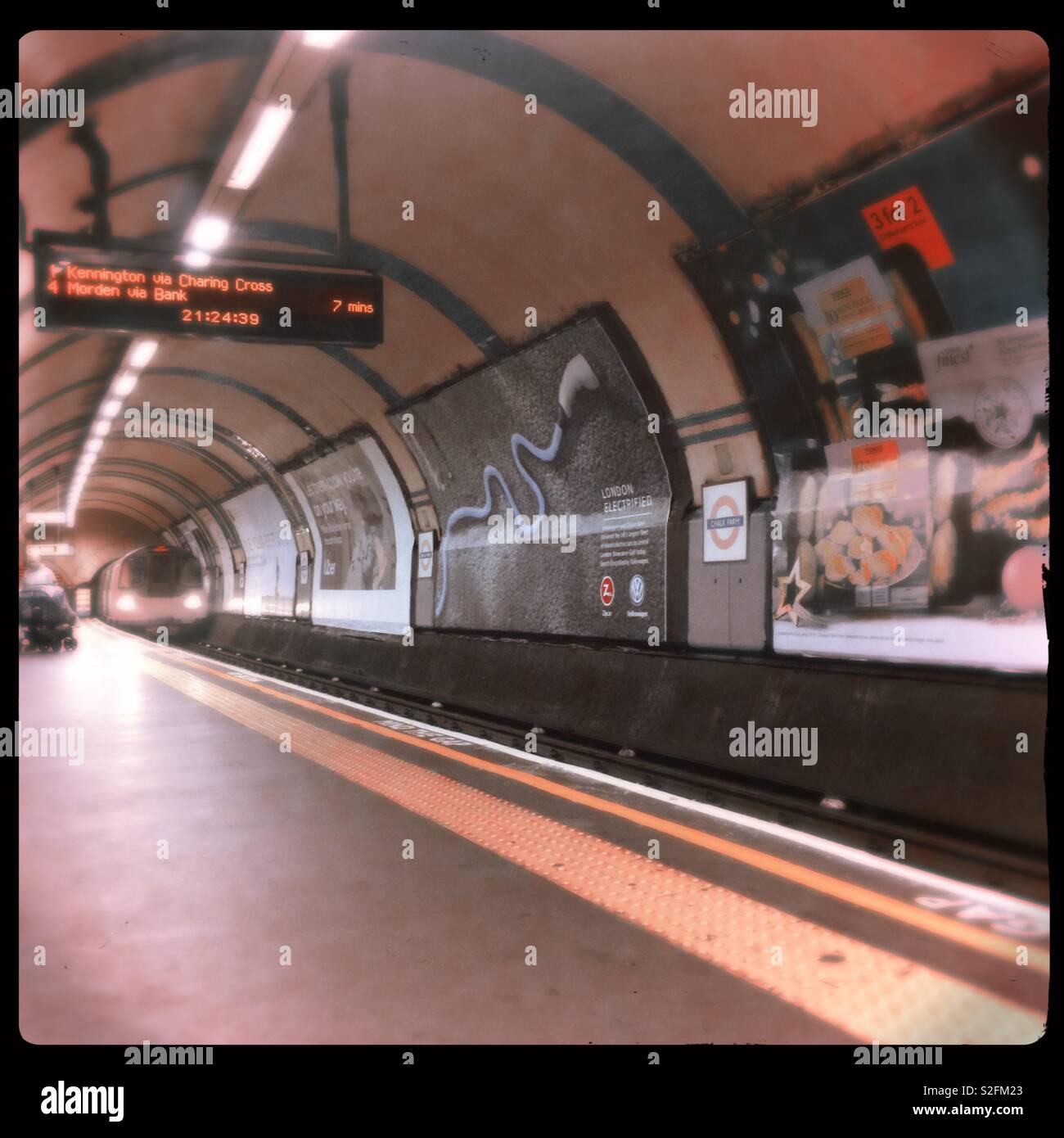 Tube station platform with tube train in distance and digital ...