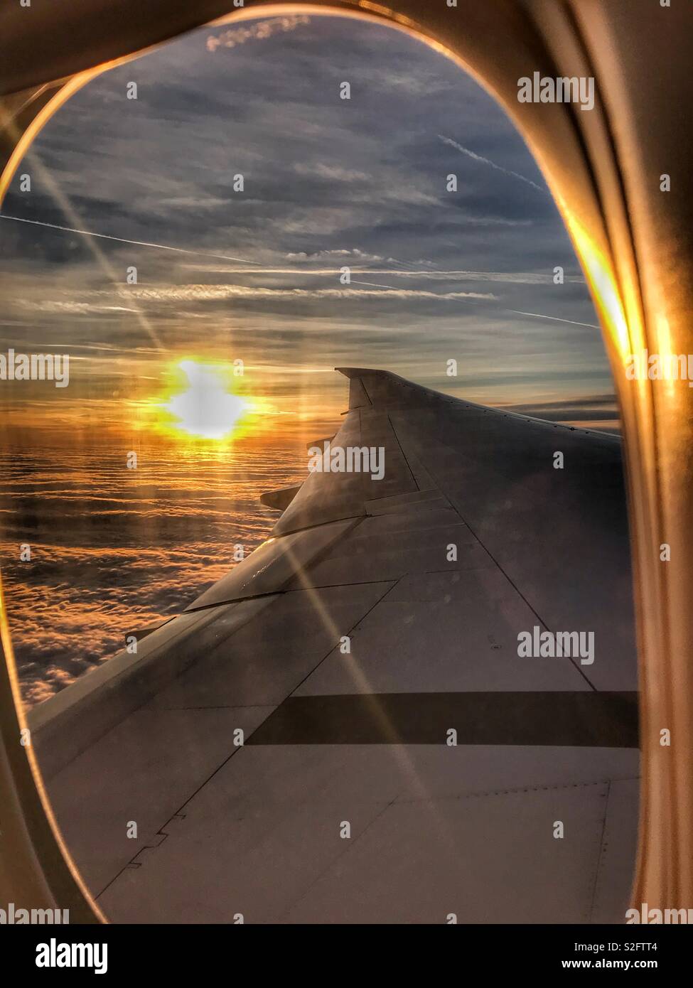 Sunset above the clouds from an airplane window Stock Photo - Alamy