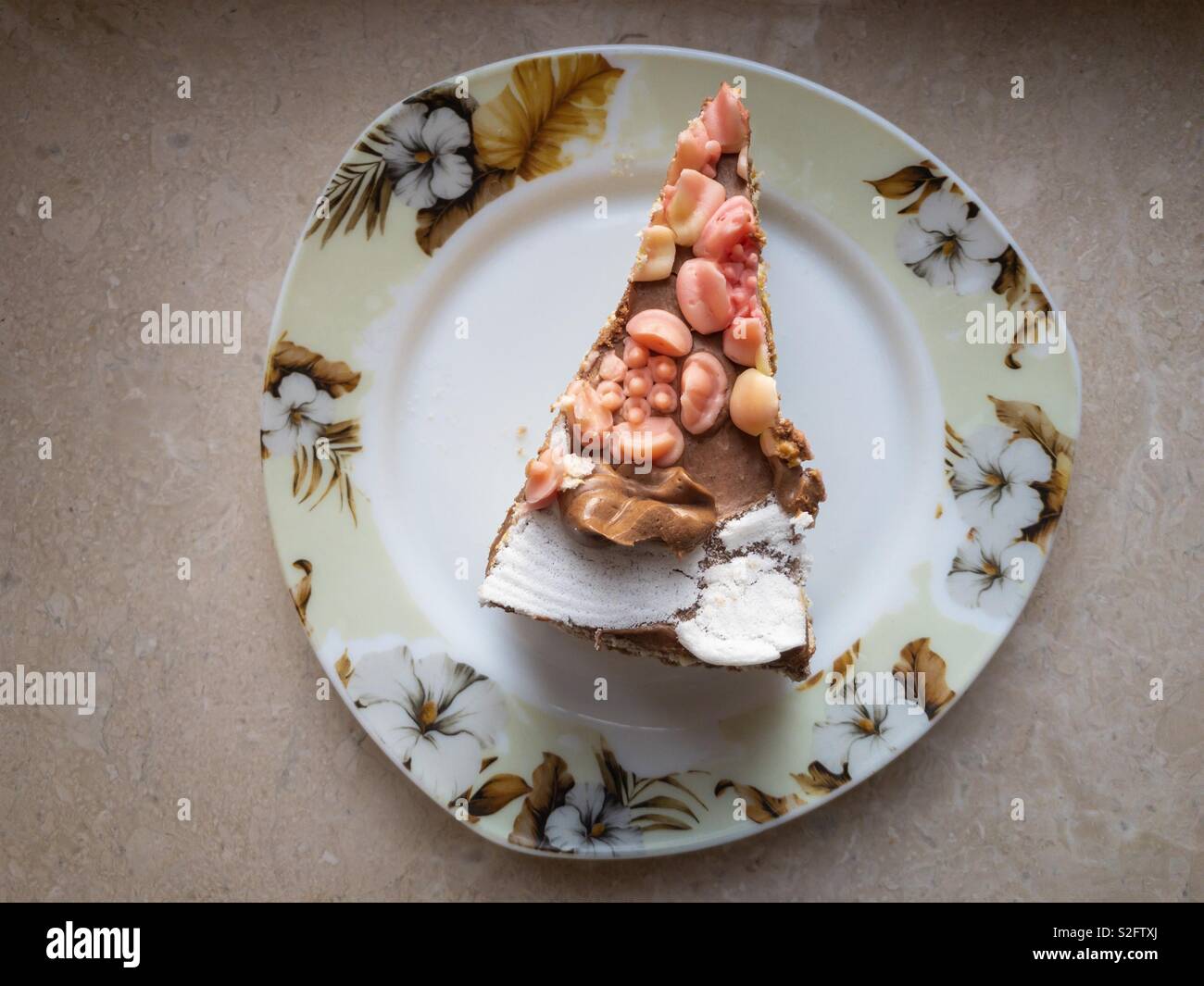 Triangle piece of meringue cake with flowers as cream on a triangle ...