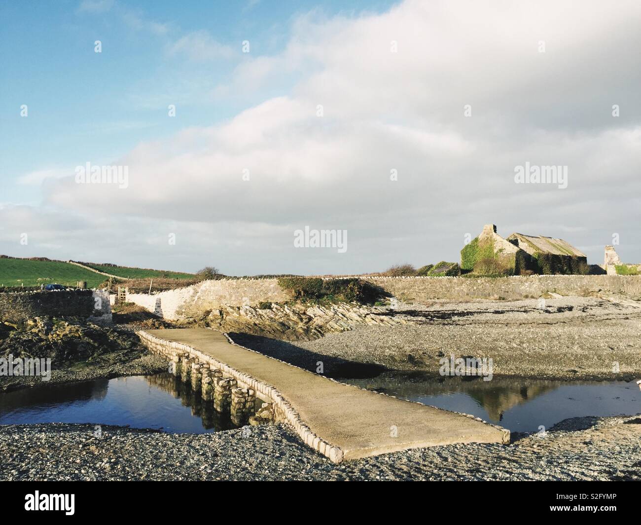 Building and walkway over stream at the Nature Reserve at Cemlyn Bay ...