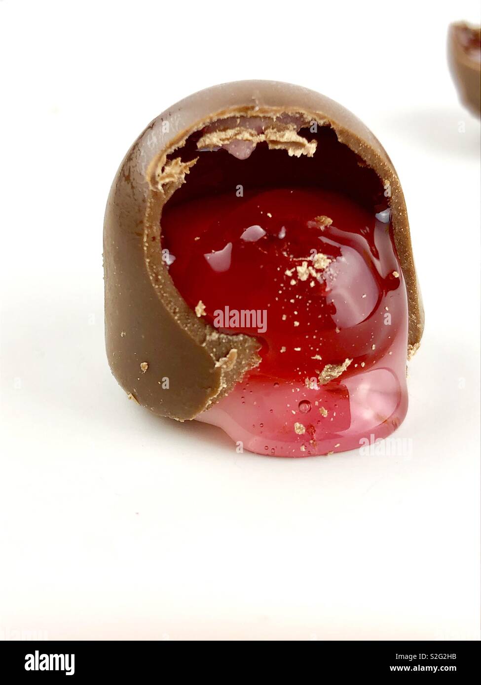 Bitten chocolate covered cherry Stock Photo - Alamy