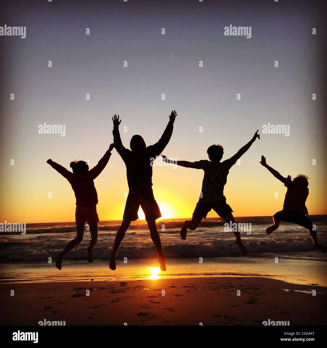 Kids jumping beach sunset hi-res stock photography and images - Alamy