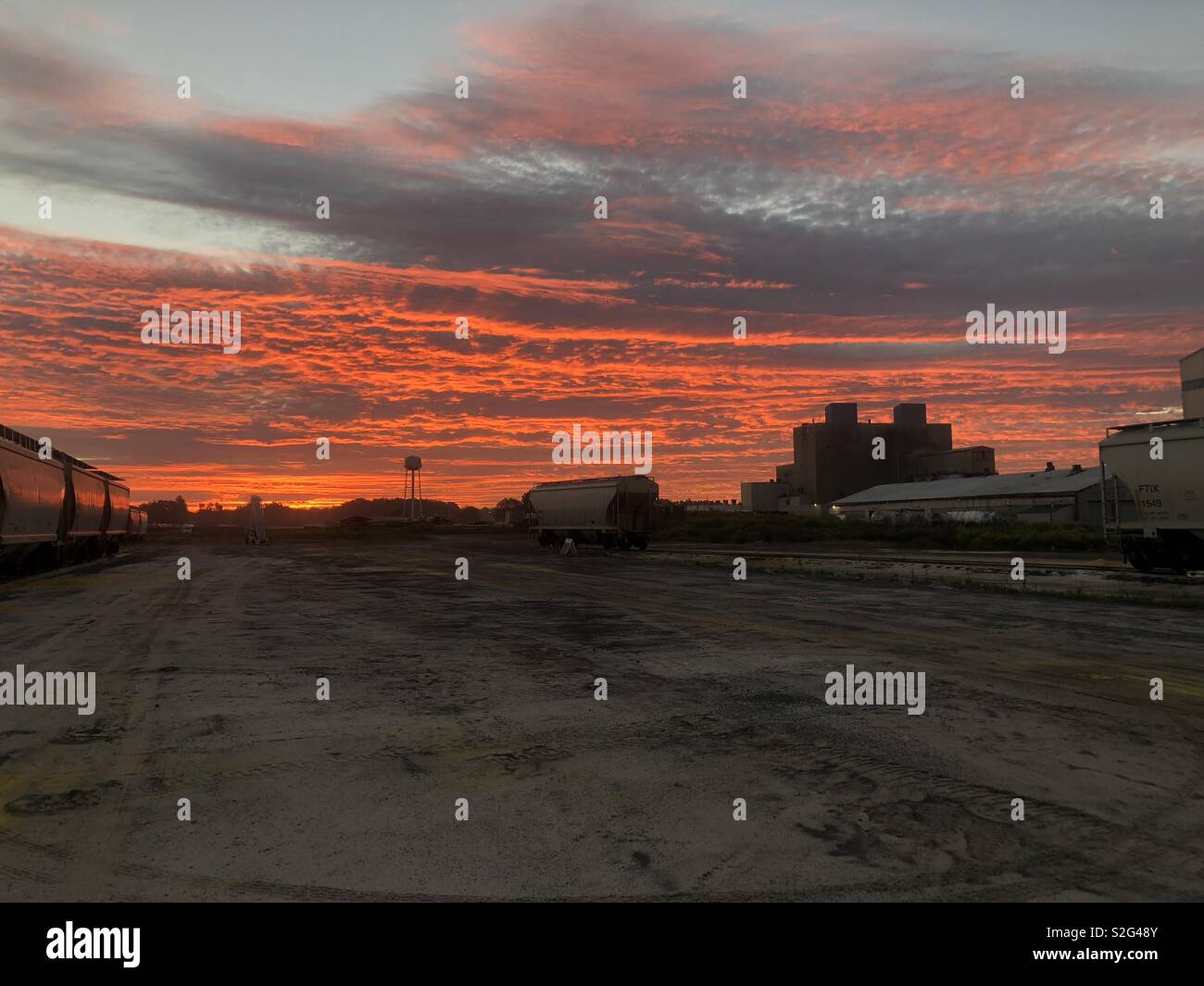 Sunset, sunrise with train cars and old factory Stock Photo - Alamy