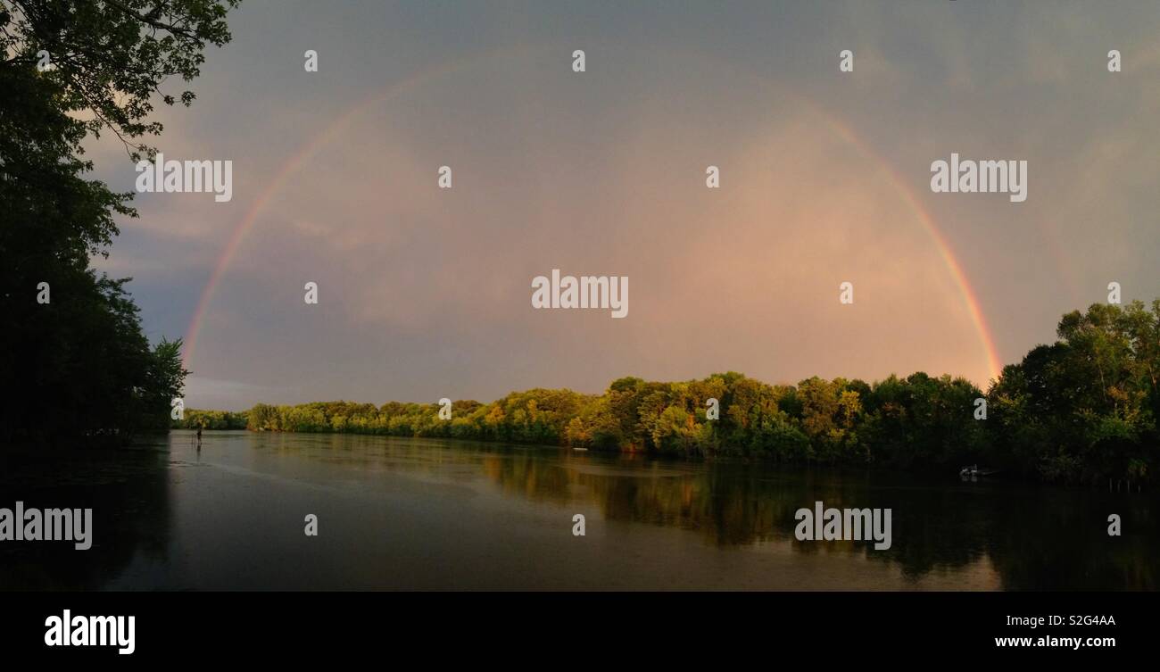Rainbow over river Stock Photo - Alamy