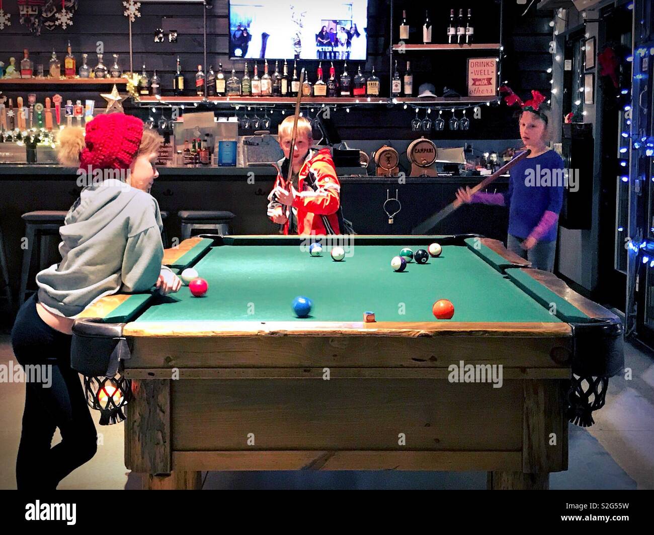Three children play pool at a pub Stock Photo - Alamy