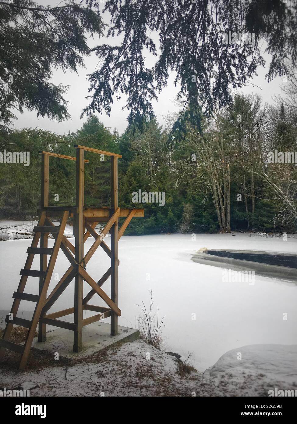 Winter time at the swimming hole, ice covered river with the wooden ...