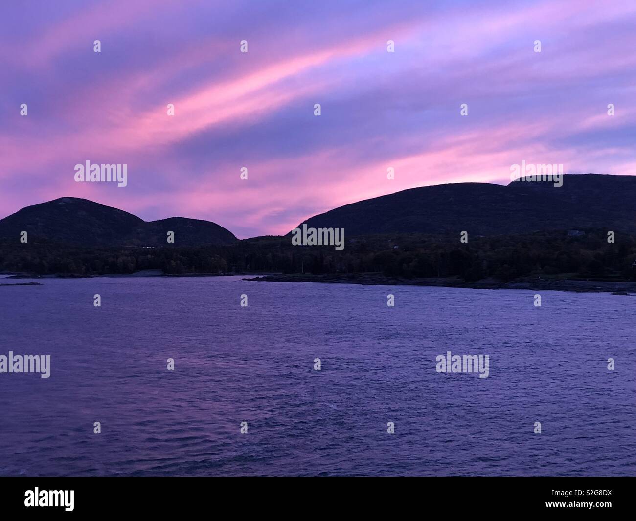 Purple and Pink Sunset over the water Stock Photo - Alamy