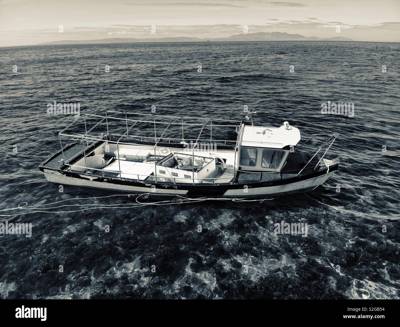 Small Boat stuck on the rocks in the incoming tide Stock Photo - Alamy