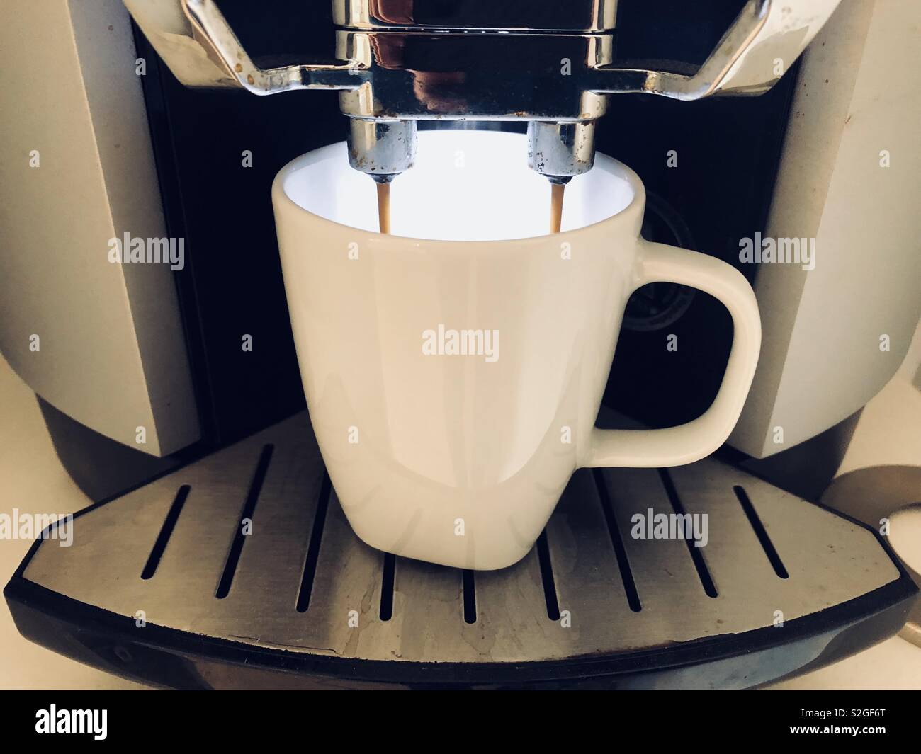 Coffee flowing into cup from coffee machine Stock Photo - Alamy