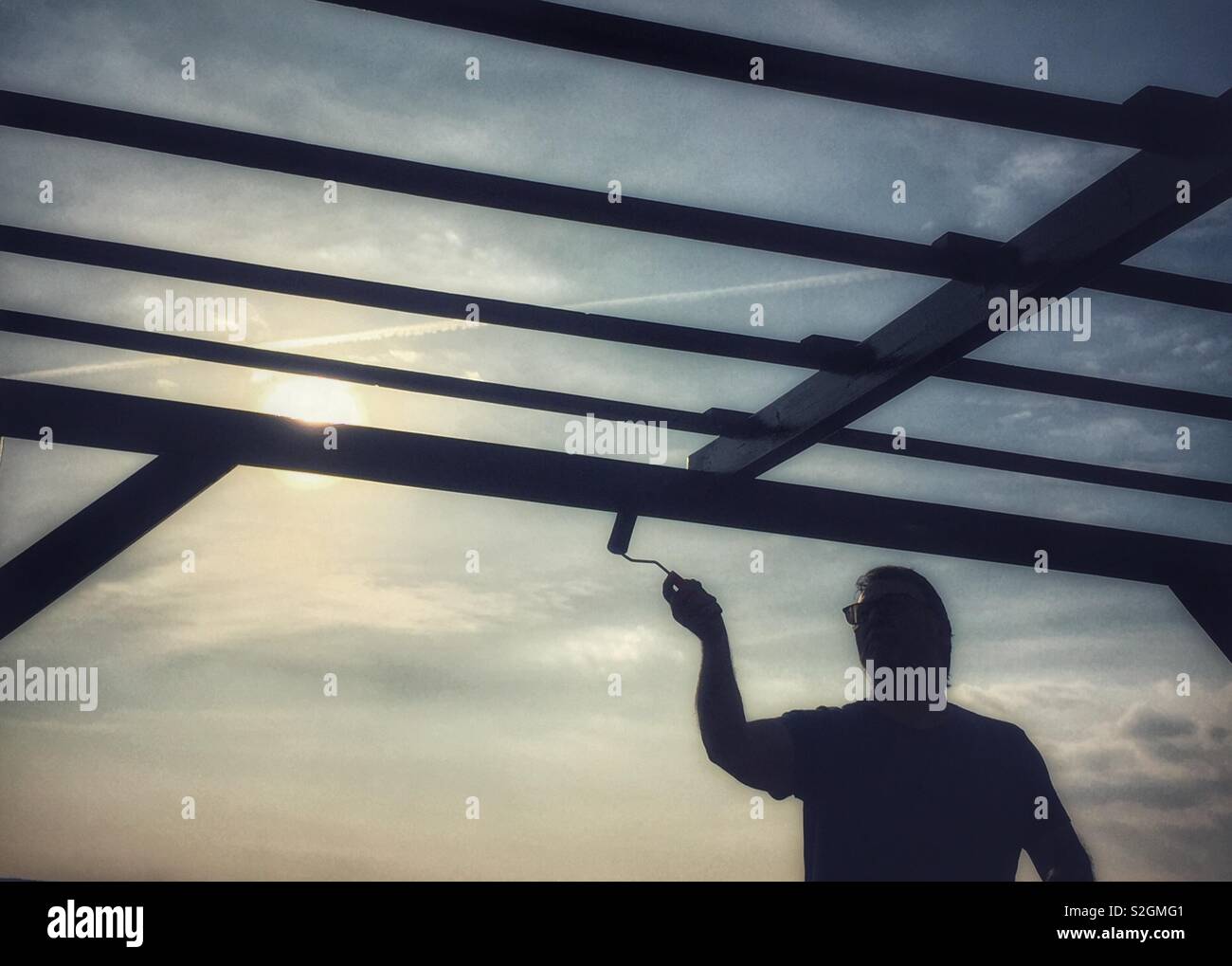 Man painting wooden structure Stock Photo - Alamy
