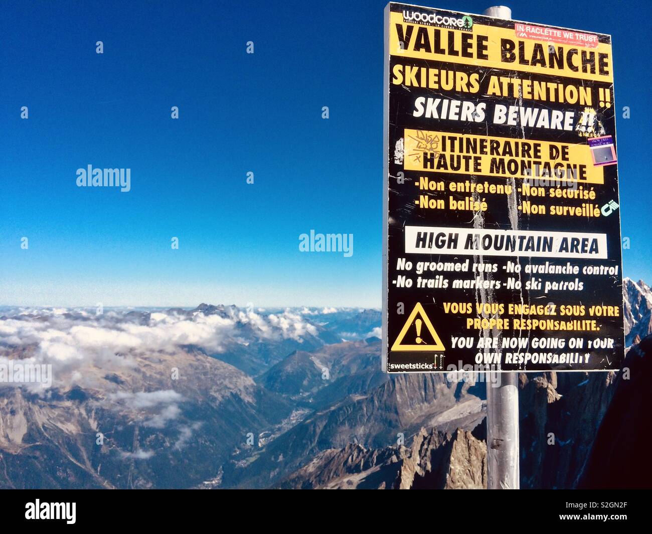 Warning sign about dangerous mountain path with view across mountain ...