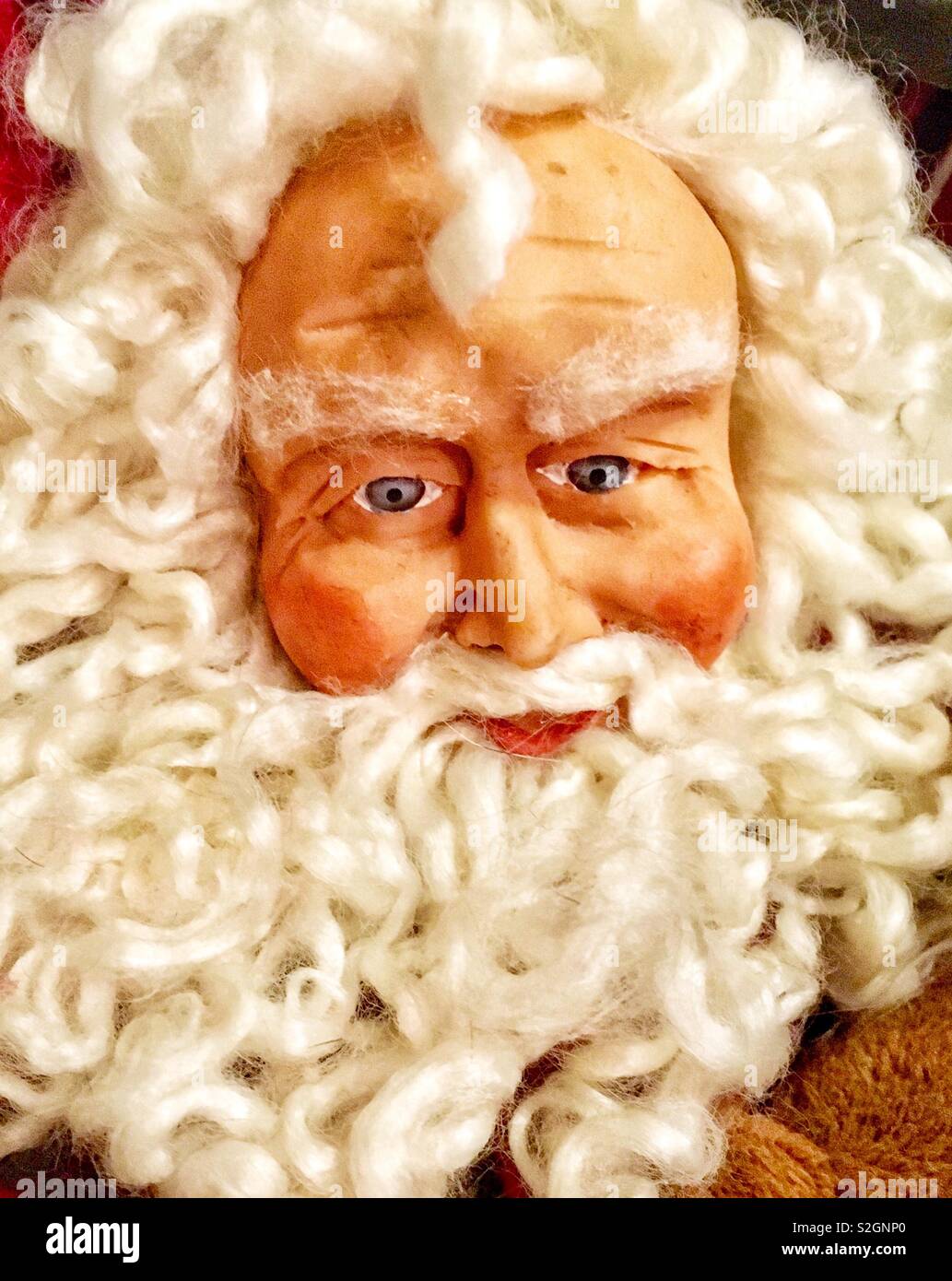 Closeup of face of Santa doll with blue eyes rosy cheeks fluffy white ...
