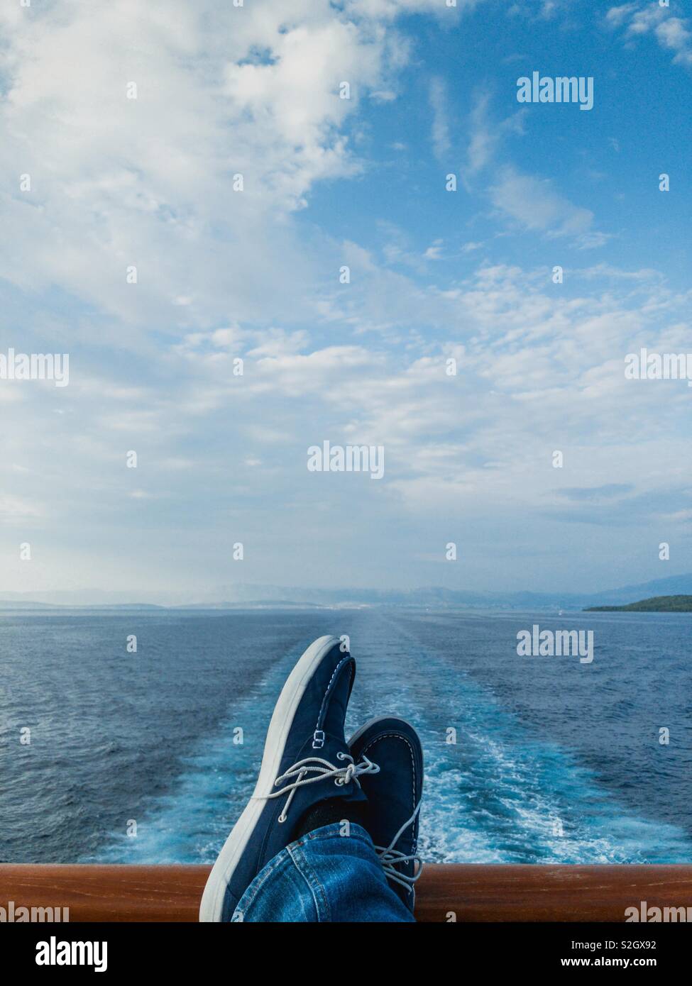 Man resting on rear end of cruise ship boat Stock Photo - Alamy
