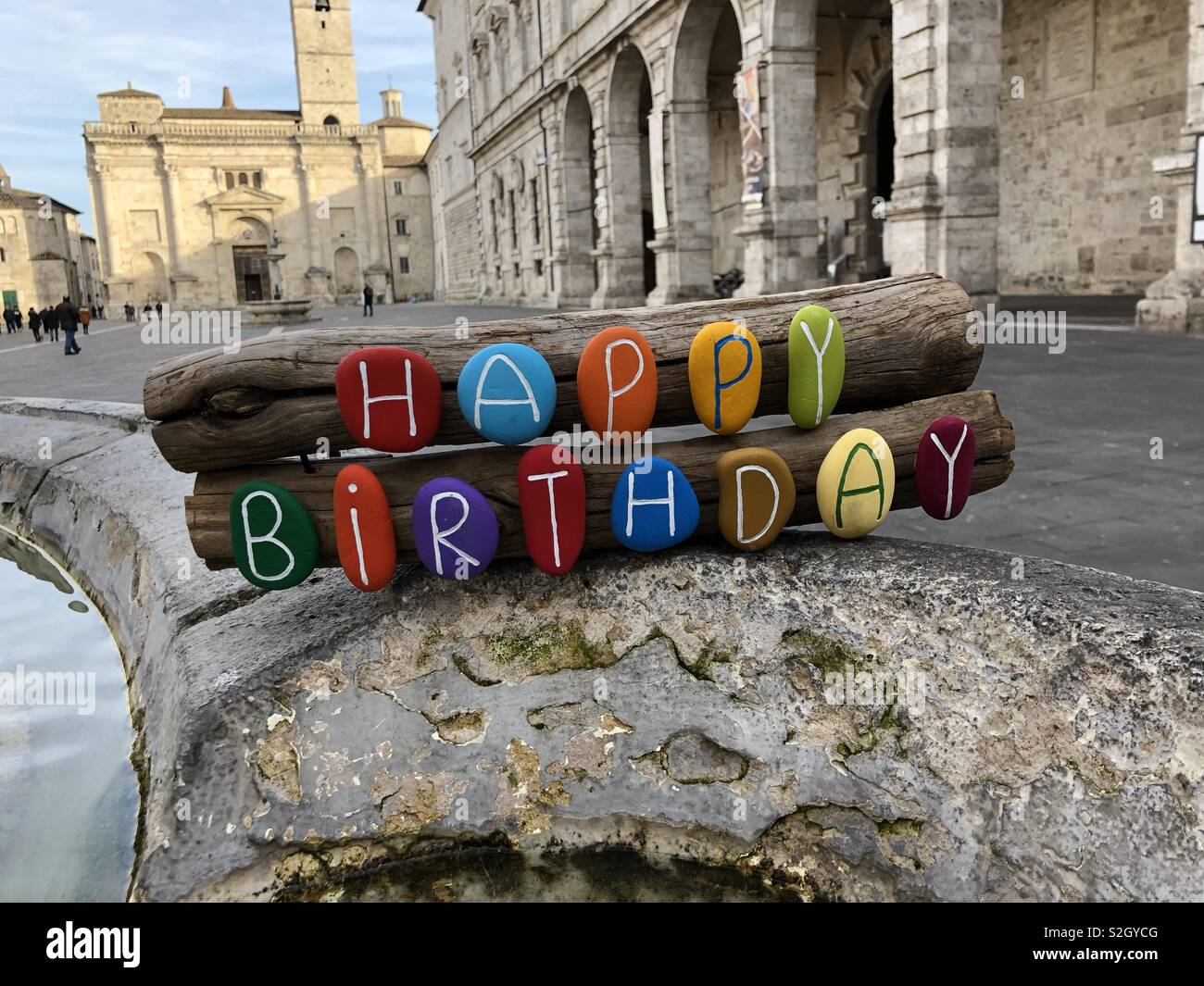 Happy Birthday text with a multi colored stones composition on a ...