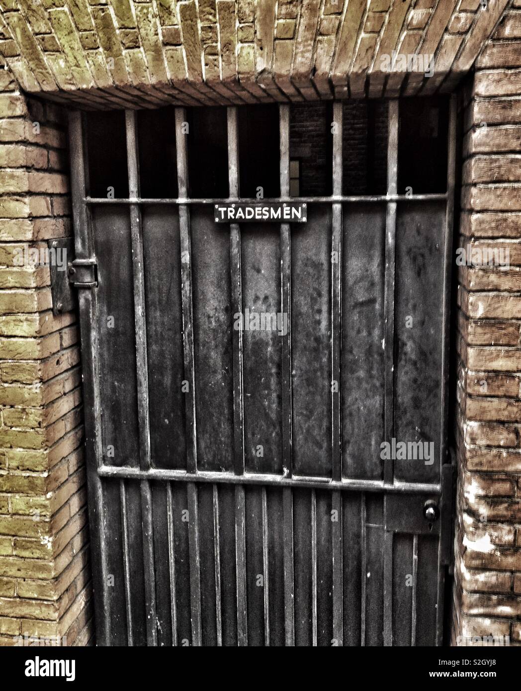 An old fashioned tradesmen entrance sign on the gate of a house in ...