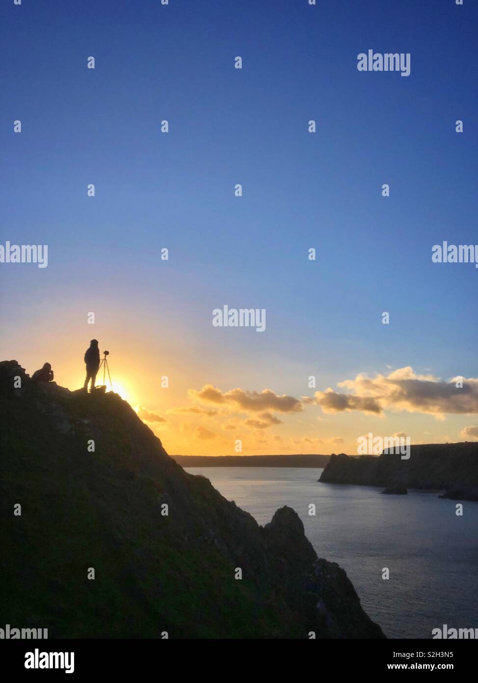 Photographer shooting a sunset on the Gower coast, Wales Stock Photo ...