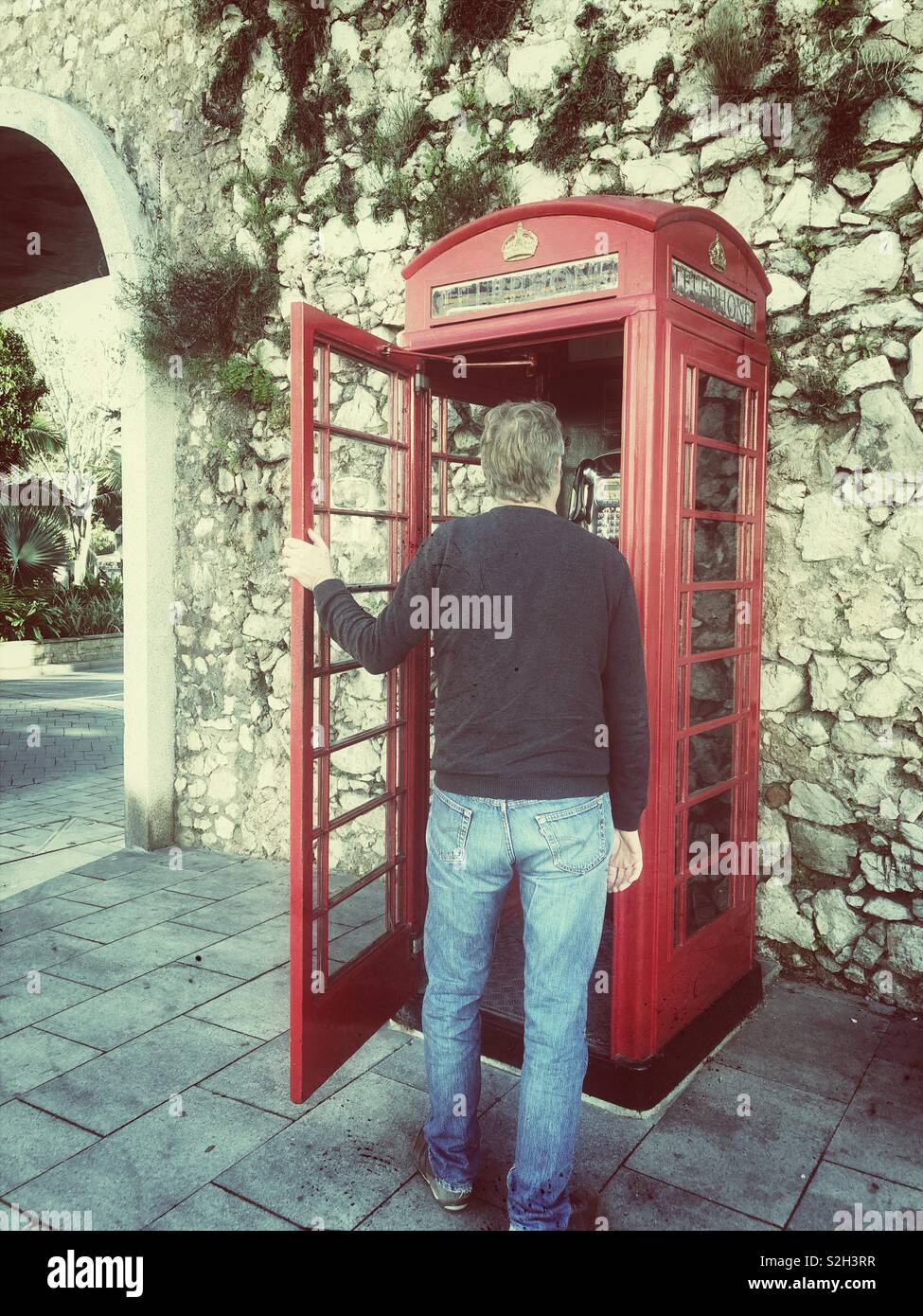 Man opening door of telephone box Stock Photo - Alamy