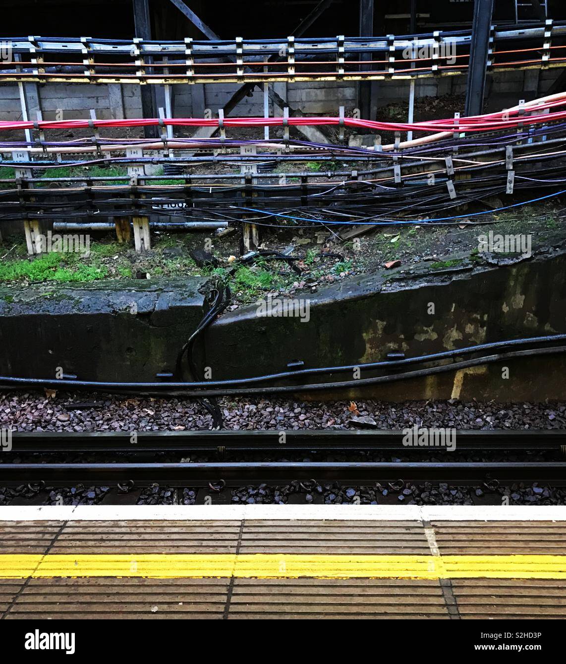 Train platform with tracks, cables, brickwork background, lots of ...