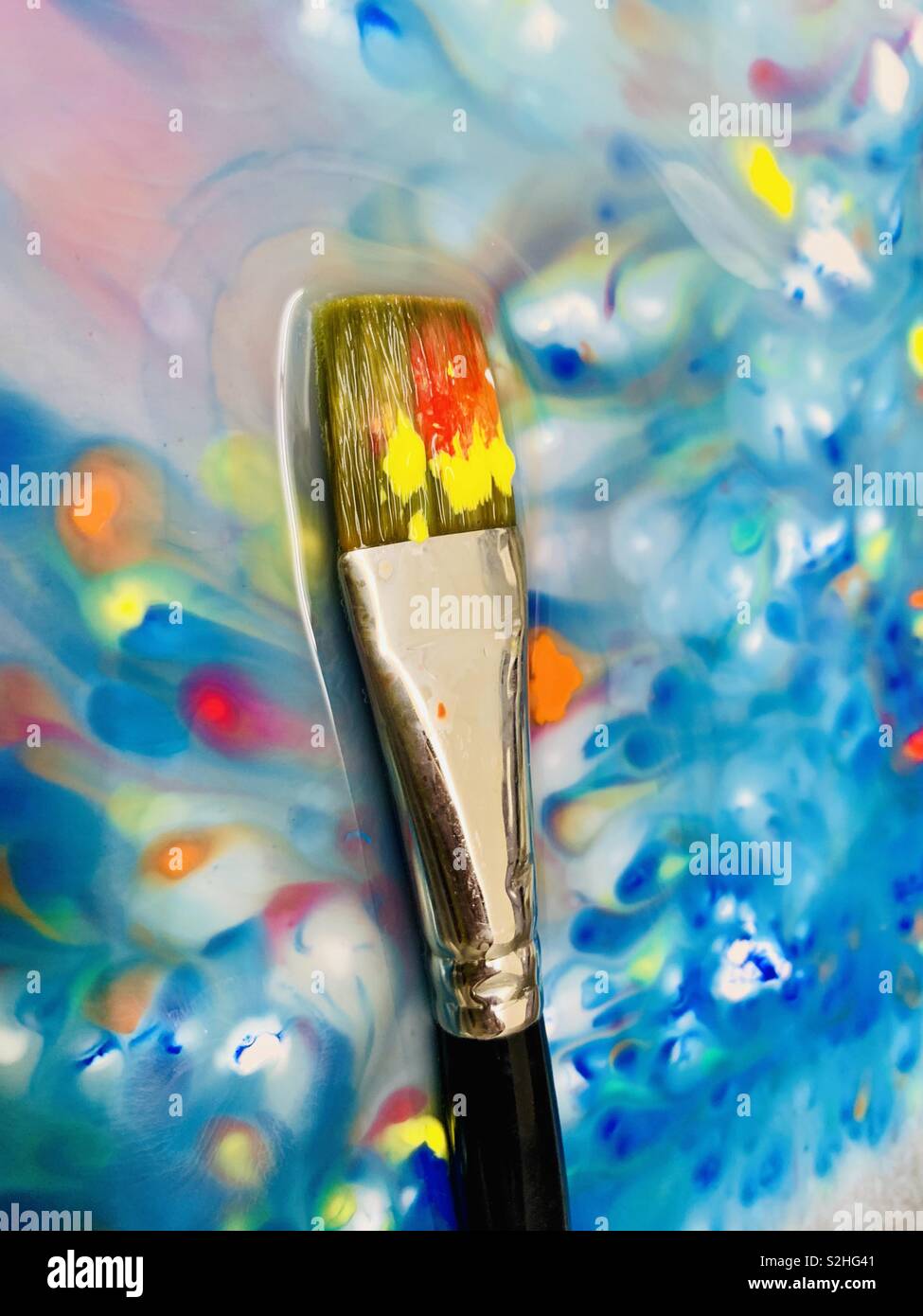 Paintbrush in a puddle of paint colors and water Stock Photo - Alamy