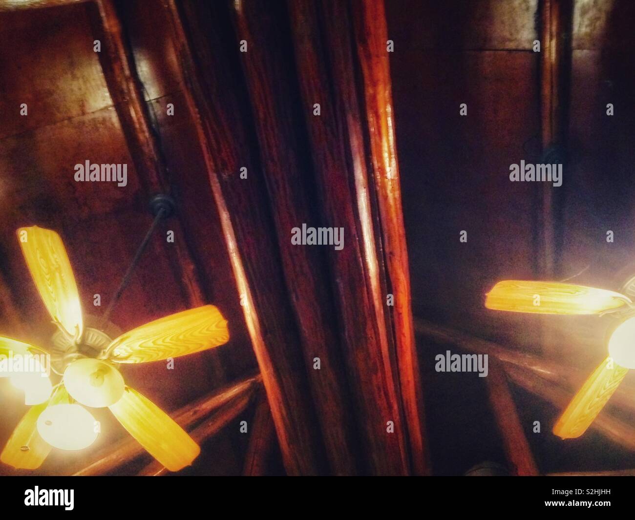 View upward to ceiling, catwalk, and 2 ceiling fans in old cabin Stock ...