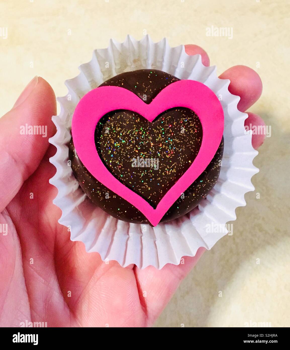 Person holding chocolate dipped Oreo with edible rainbow glitter and ...