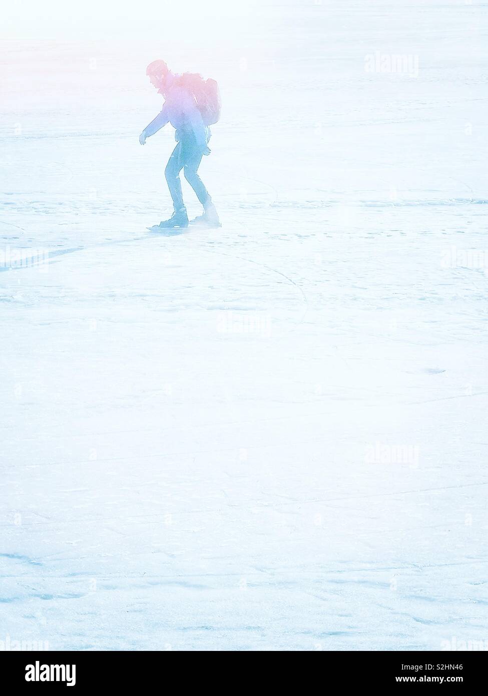 Man long distance ice skating in mist and sunshine on Lake Malaren ...