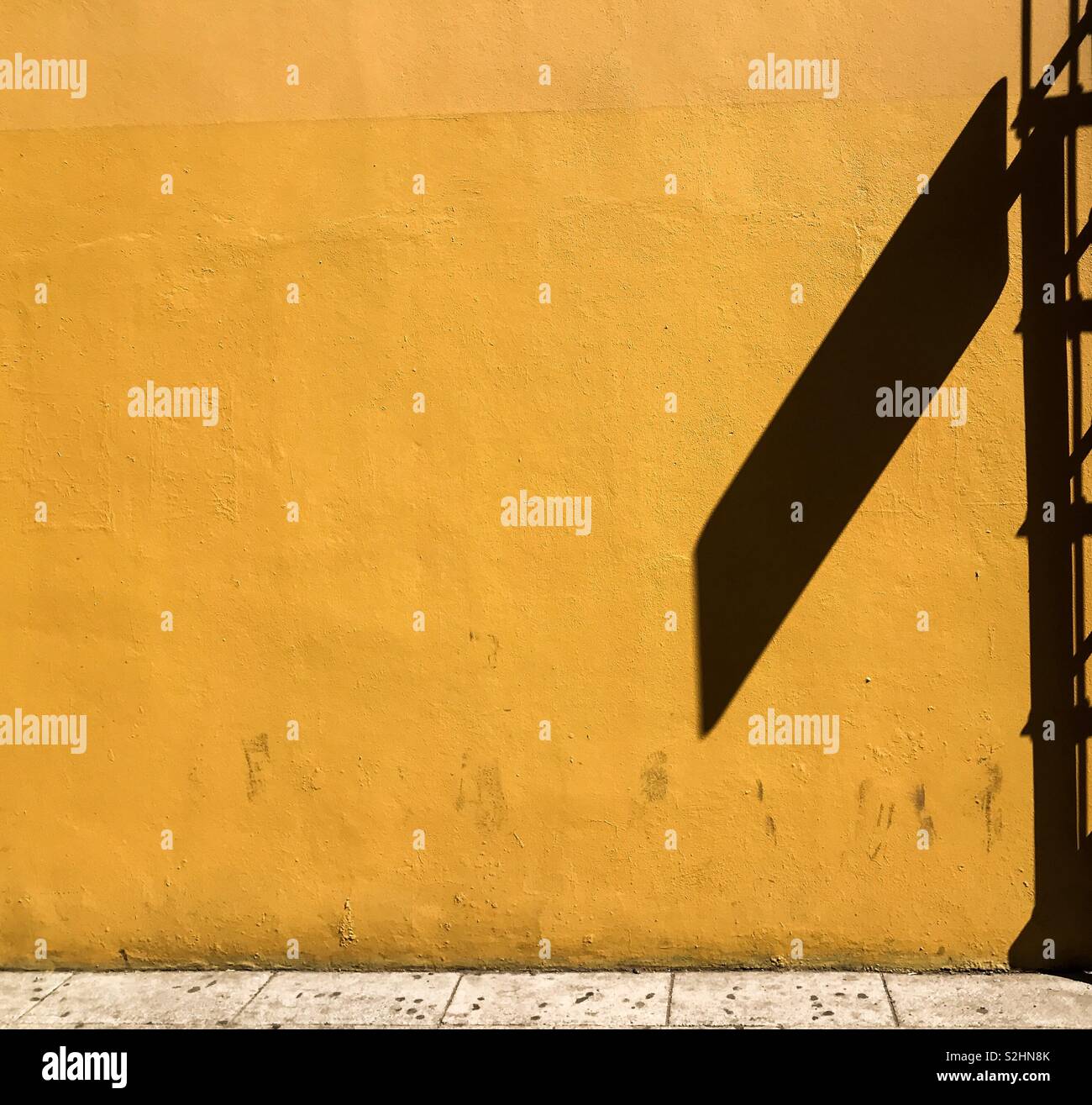 Shadow of the Law. Shadow of street sign on the bright yellow wall ...