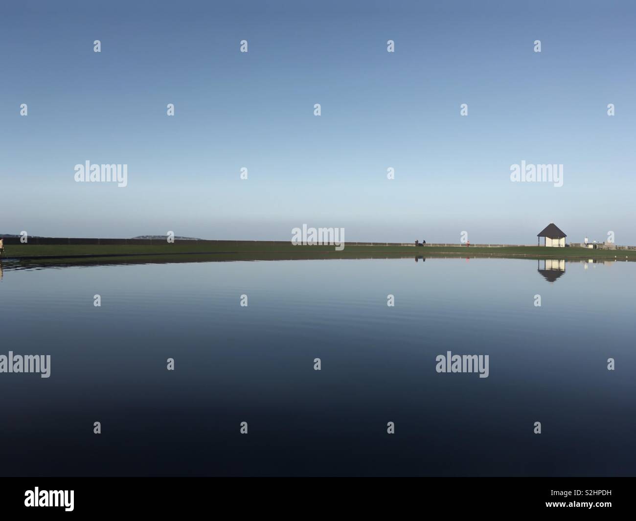A small building reflected on a lake Stock Photo - Alamy