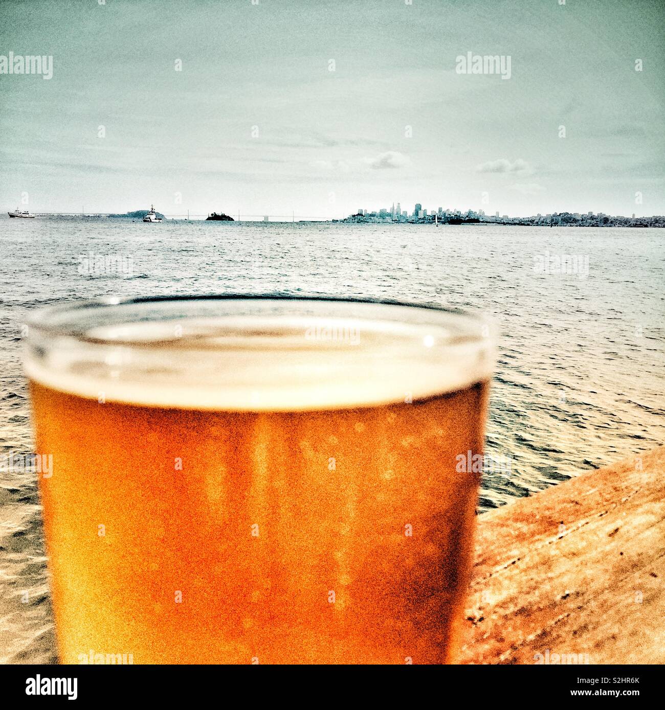 A view across San Francisco Bay to the cityscape with a pint of beer ...