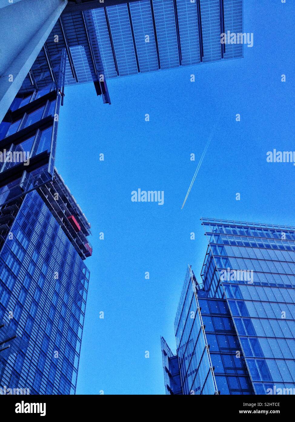 An aeroplane flying over high-rise office buildings in London, England ...