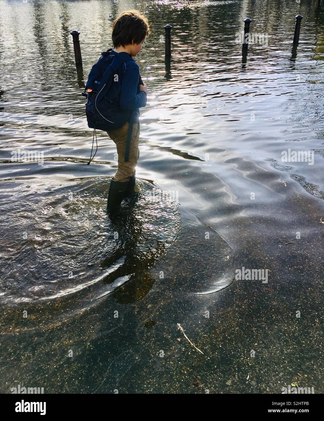 Boy standing in high tide the Thames Stock Photo - Alamy